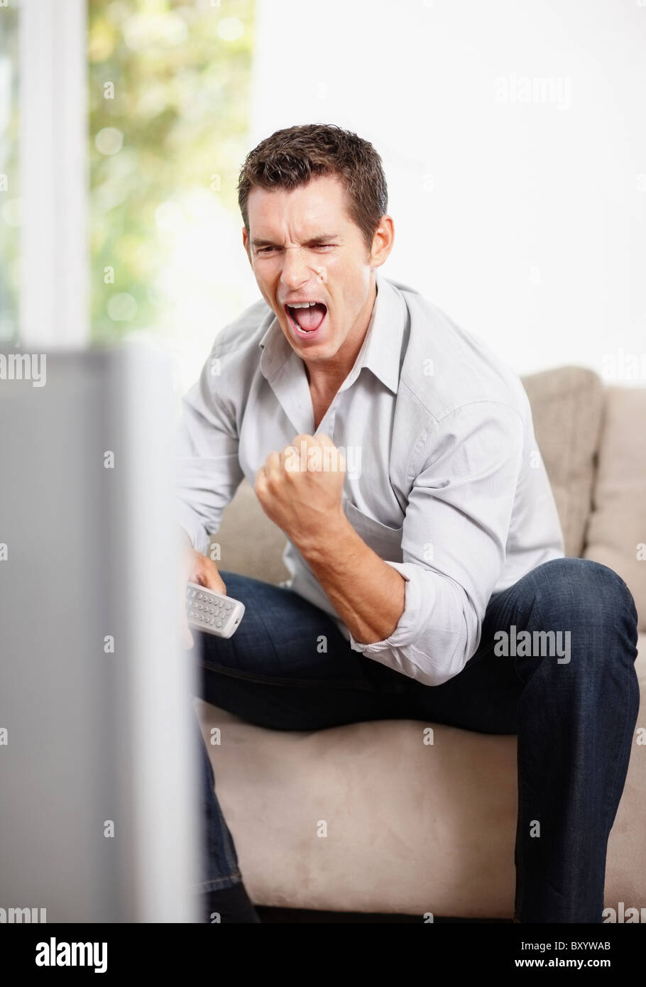 Excited man watching football match Stock Photo - Alamy