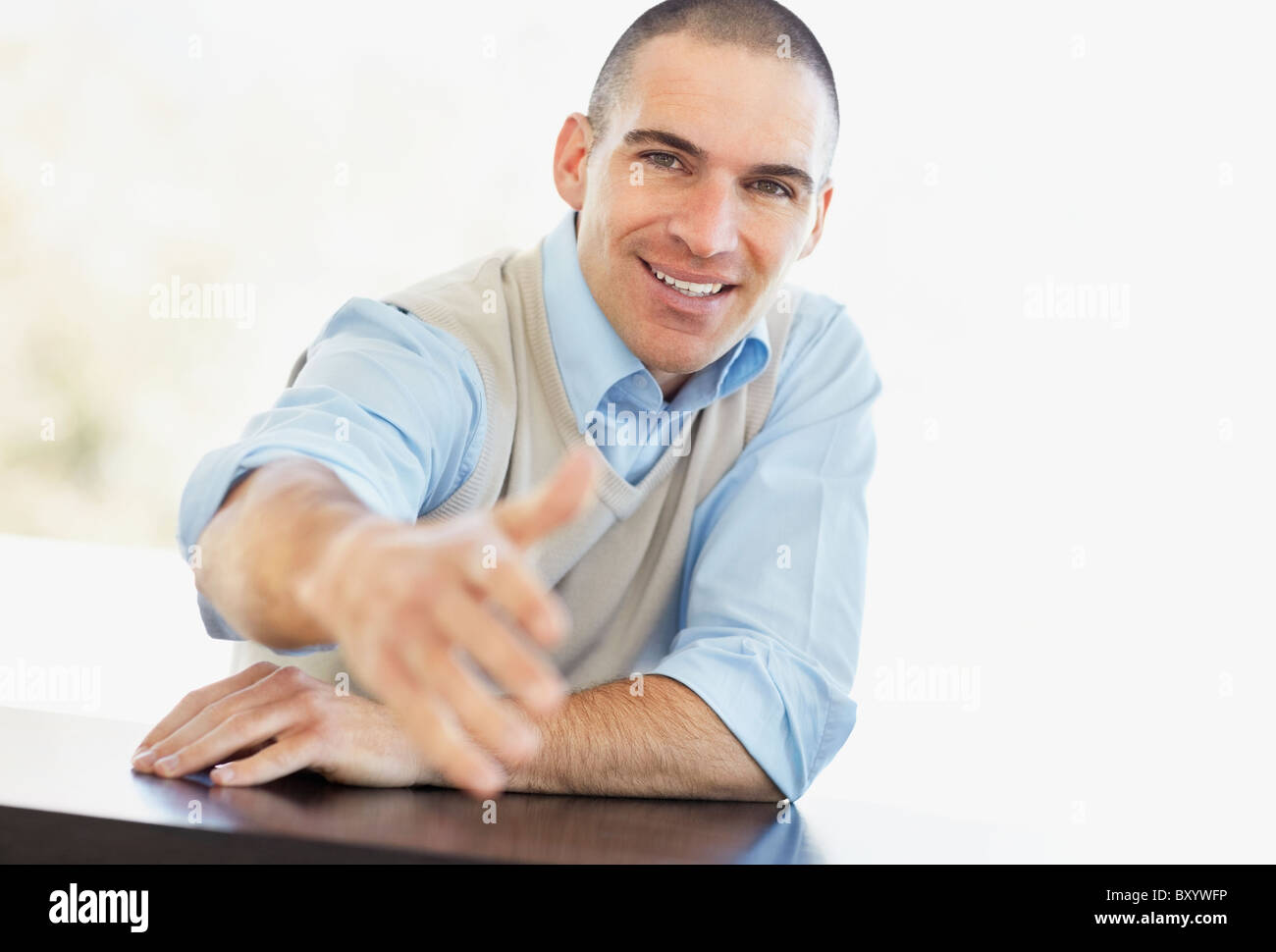 Mid adult man offering hand for handshake Stock Photo - Alamy