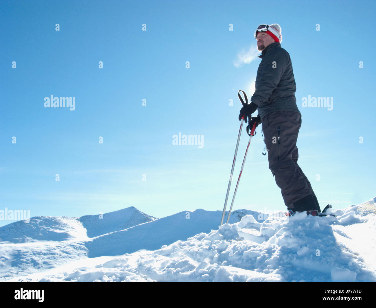 Male skier standing on mountain Stock Photo - Alamy