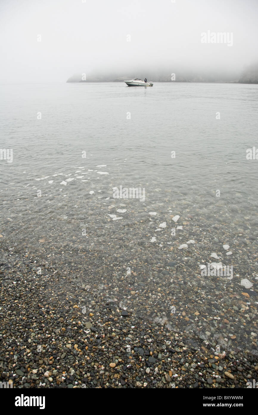 Boat near foggy beach Stock Photo - Alamy