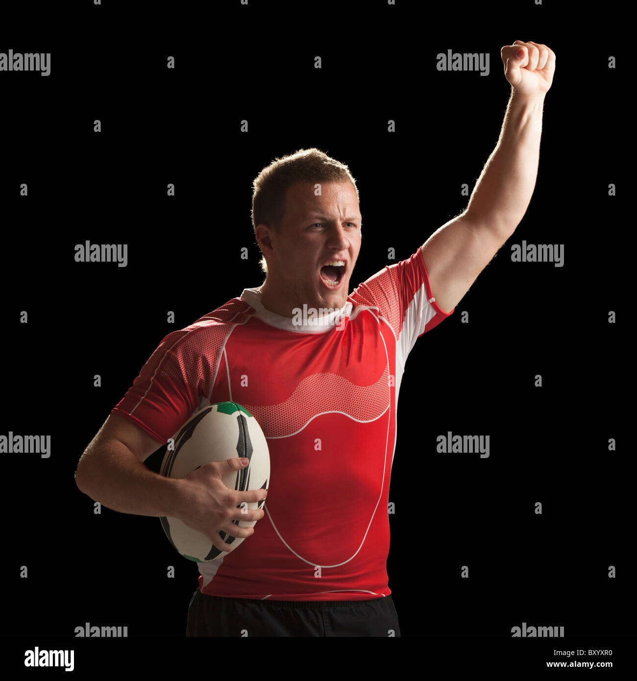 Male rugby player holding ball, celebrating Stock Photo - Alamy