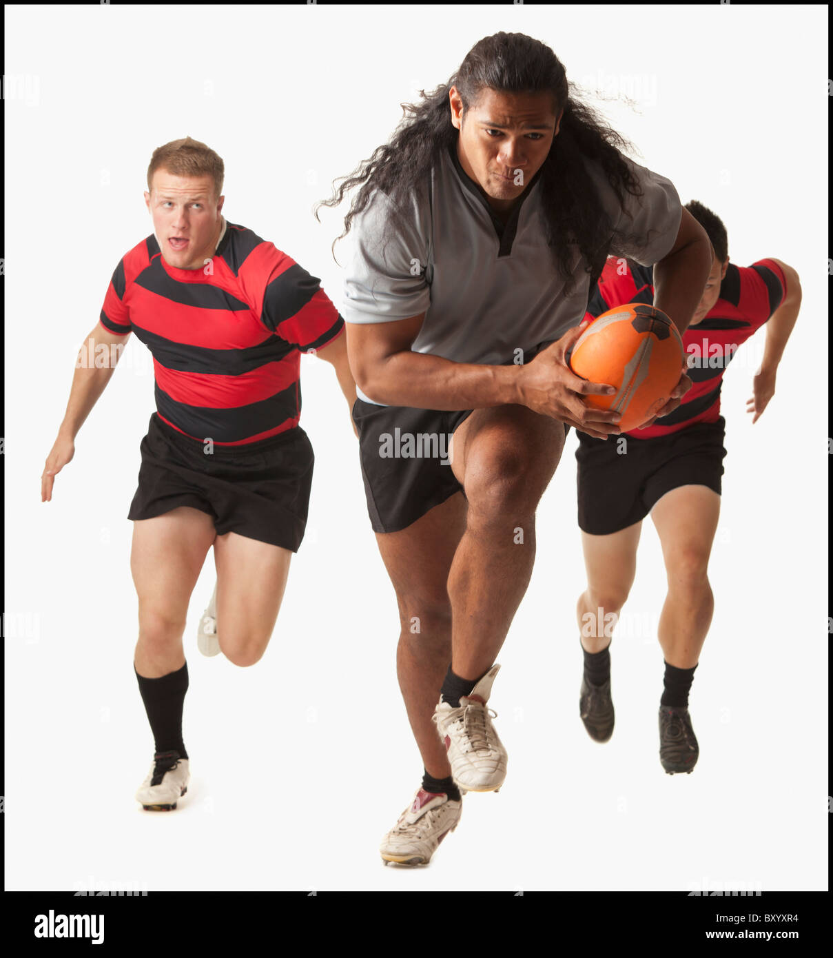 Rugby player running with ball, team chasing Stock Photo - Alamy