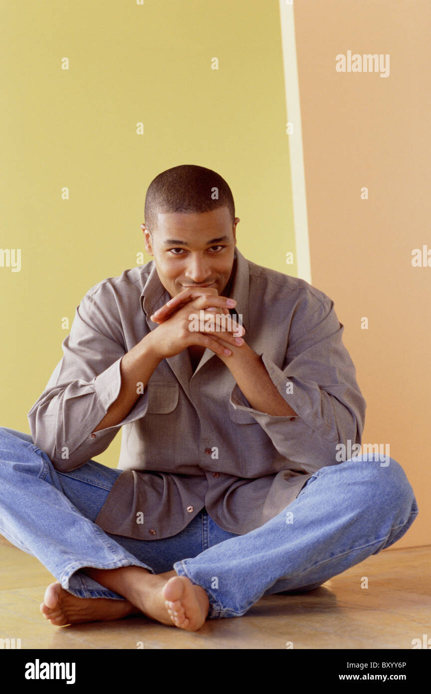Handsome man sitting cross legged Stock Photo - Alamy