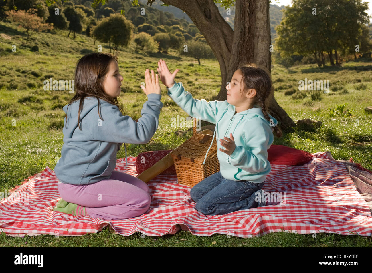 Tow girls playing a clapping game outdoor in a picnic Stock Photo - Alamy