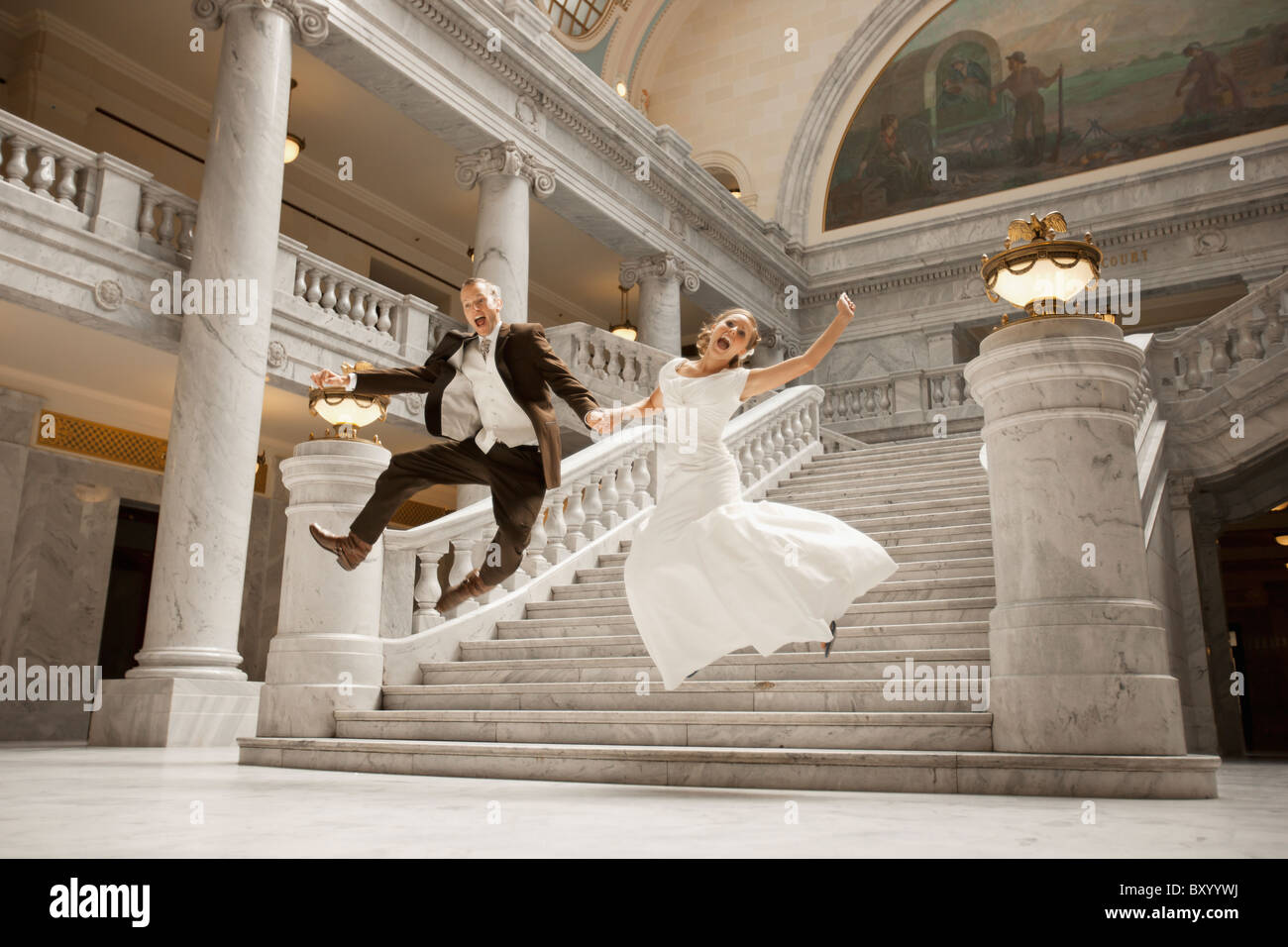 Bride and groom leaping from steps Stock Photo - Alamy