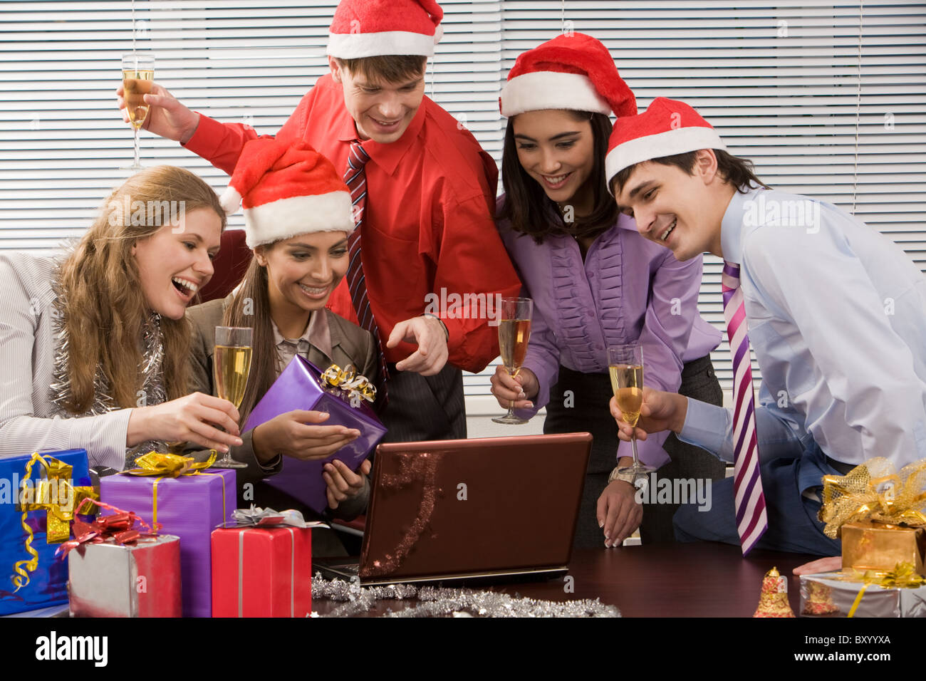 Image of joyful business group looking at screen of laptop and reading ...