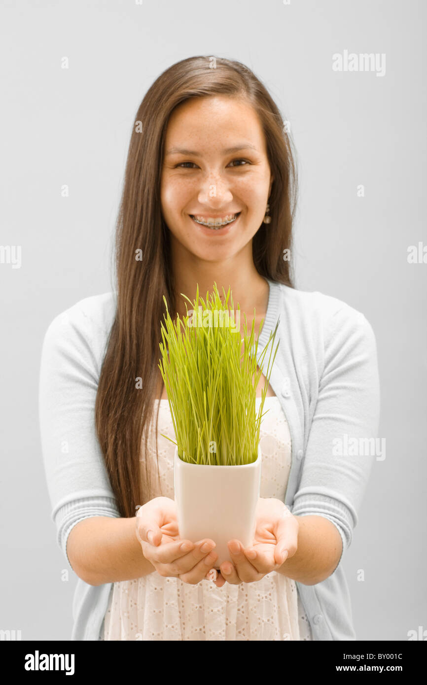 Studio portrait of young woman holding wheat grass Stock Photo - Alamy