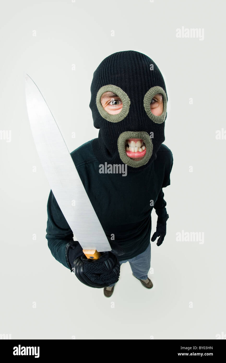 Fish-eye shot of gangster wearing black balaclava with knife in hand ...