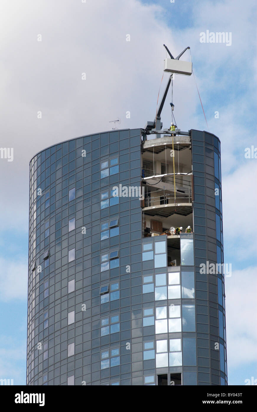 Rooftop crane lifting into place panels on the construction of the ...