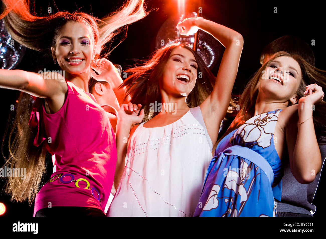 Three smart dancers moving at disco while raising their arms Stock ...