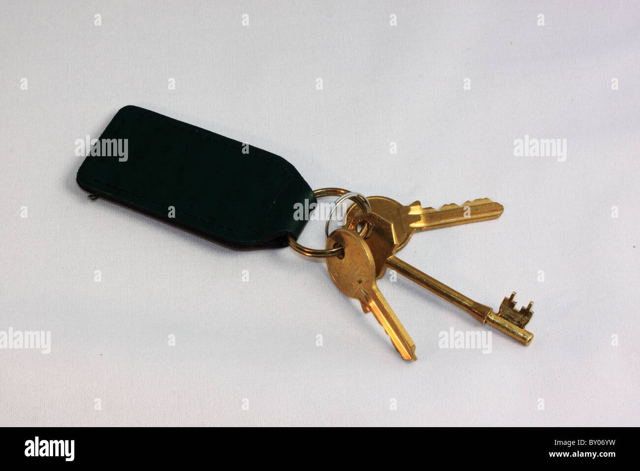 A bunch of 3 gold coloured keys on a green leather key fob Stock Photo ...