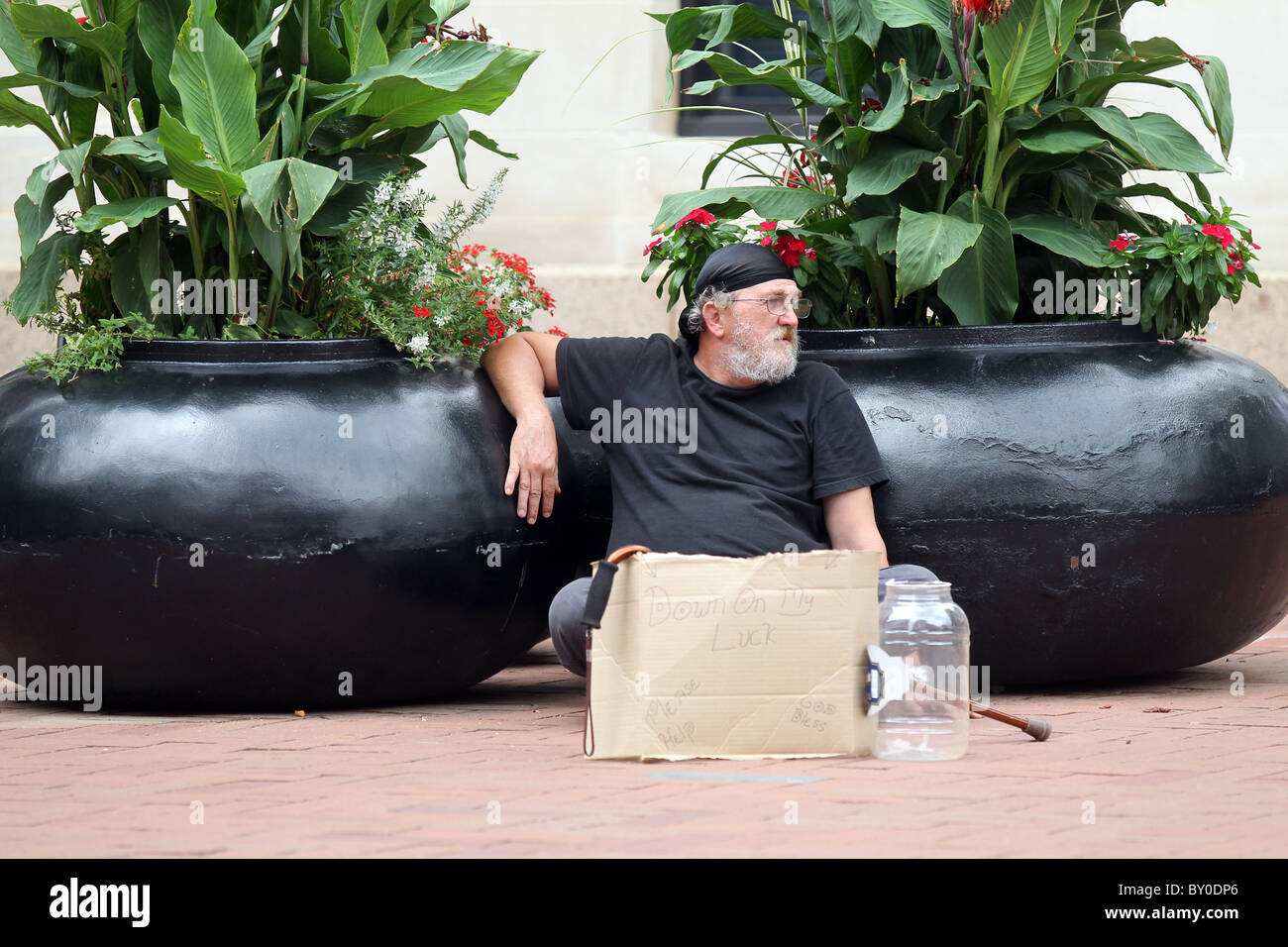 A Homeless man sits and begs for change during tough economic times on ...