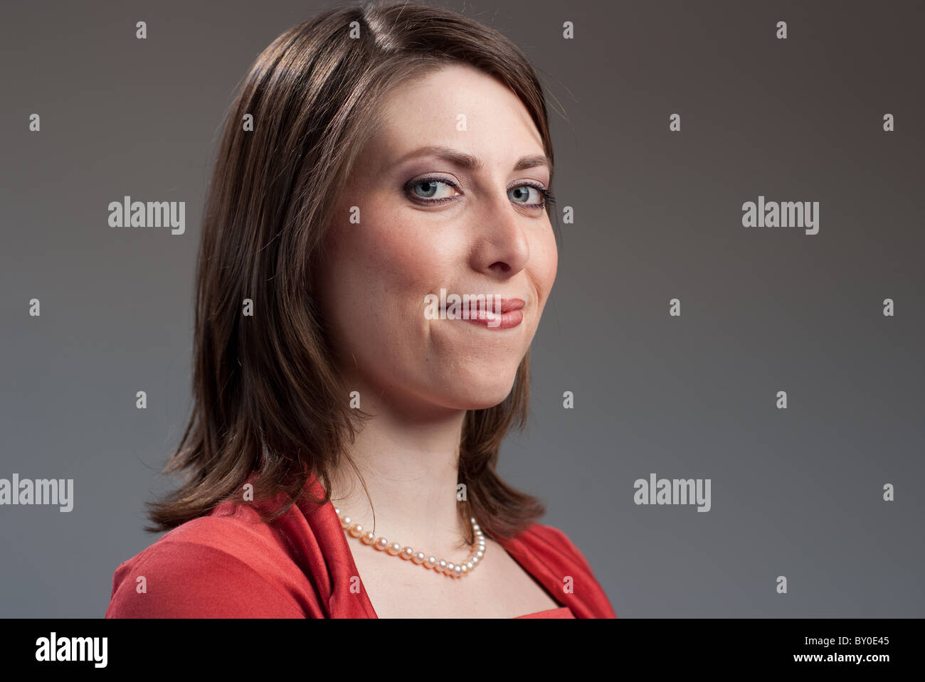 Portrait of a young pretty woman wearing a red top Stock Photo - Alamy