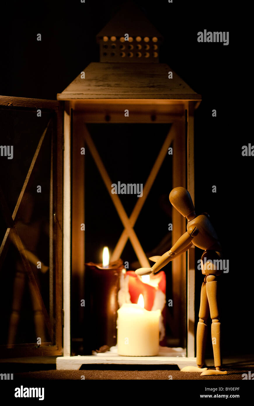 A puppet, warming up at a lantern with candles Stock Photo - Alamy