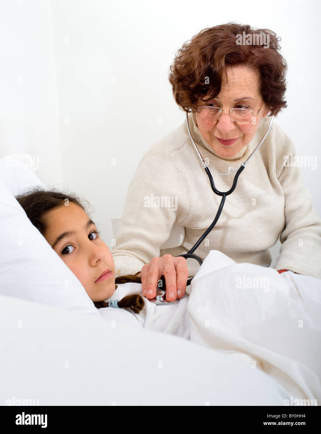 senior woman doctor checking child penitent at home Stock Photo - Alamy