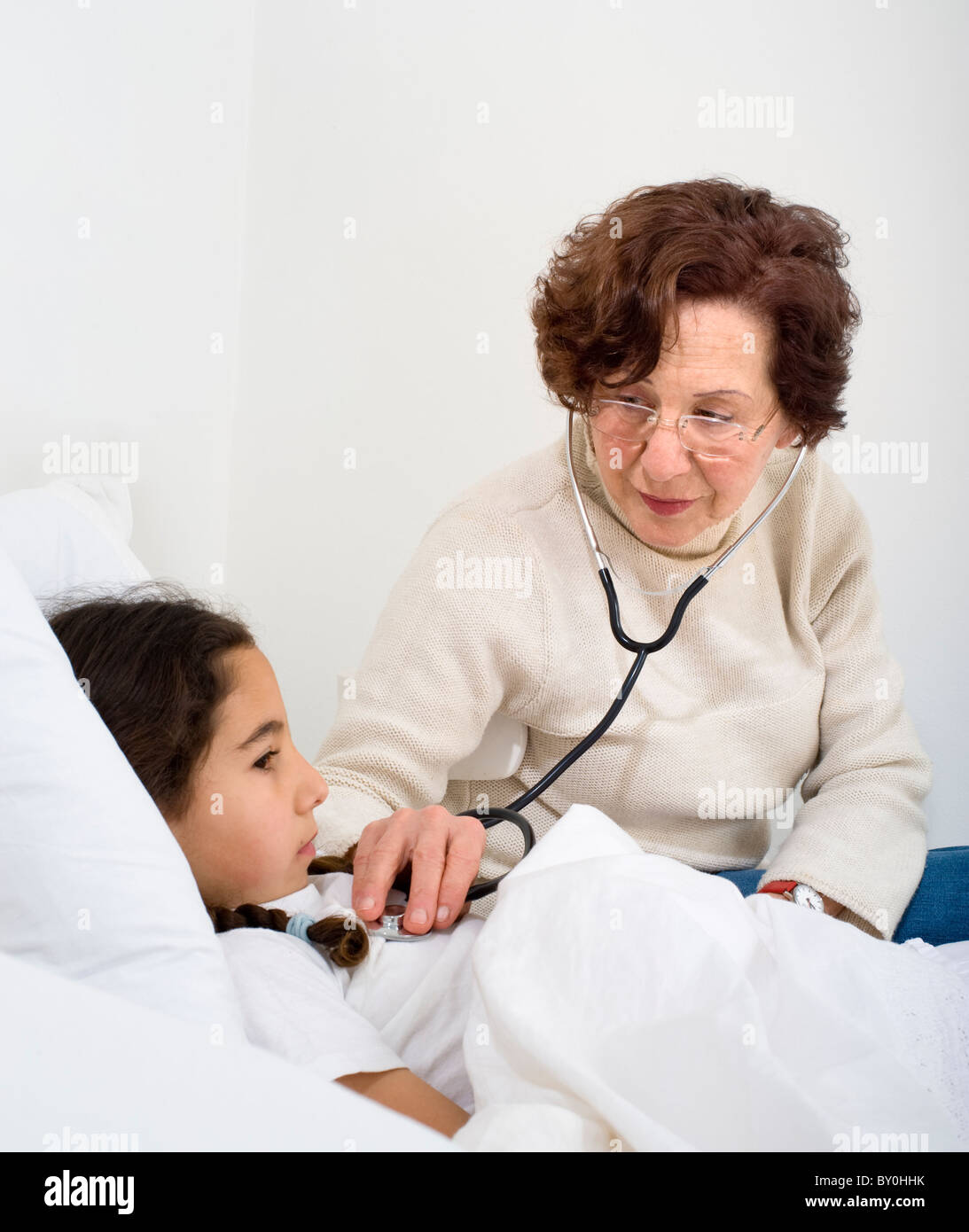 senior woman doctor checking child penitent at home Stock Photo - Alamy