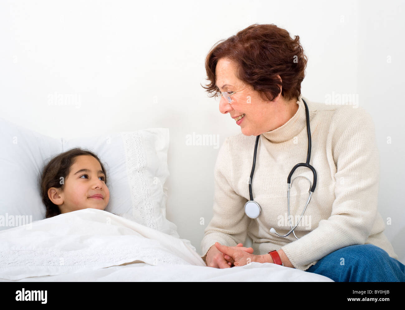 senior woman doctor visiting child penitent at home Stock Photo - Alamy