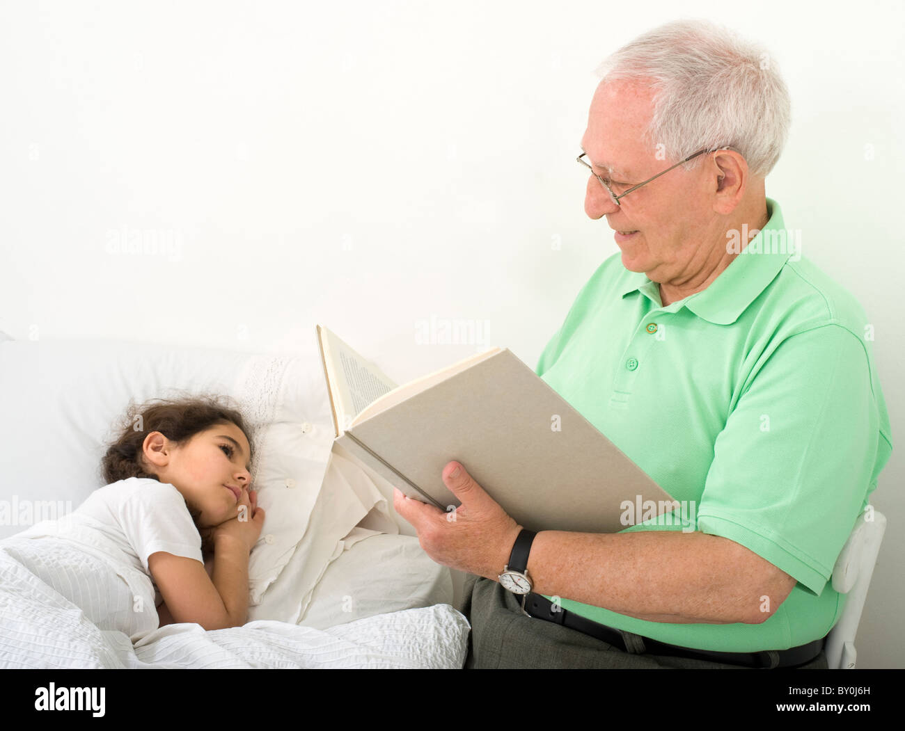 grandfather reading to grandchild a bed time story Stock Photo - Alamy