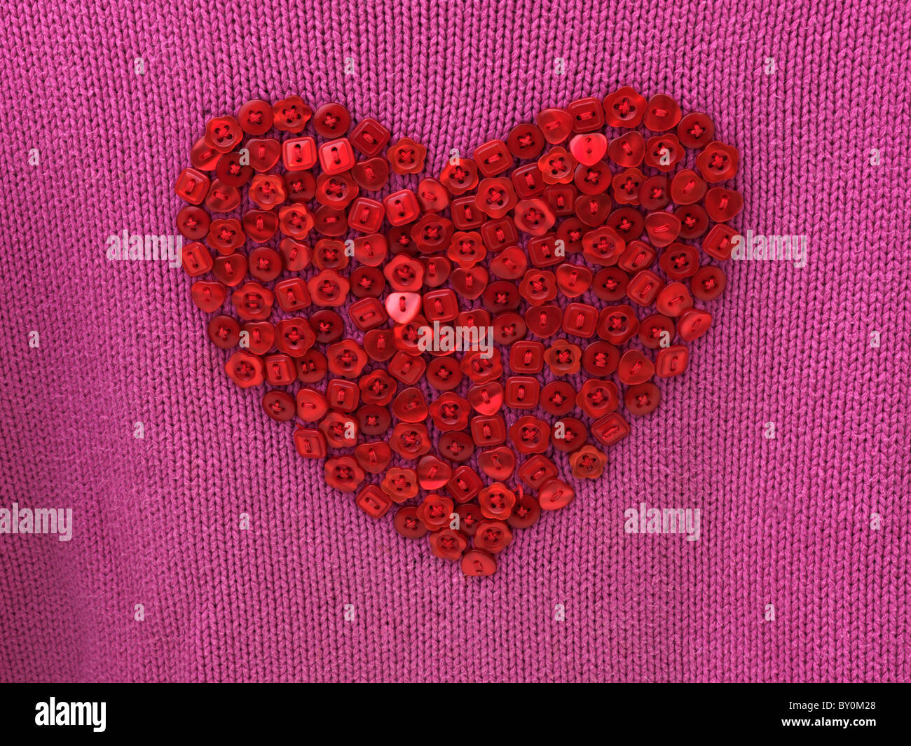 Close Up Of A Child's Pink Jumper With Heart Pattern made From Buttons ...