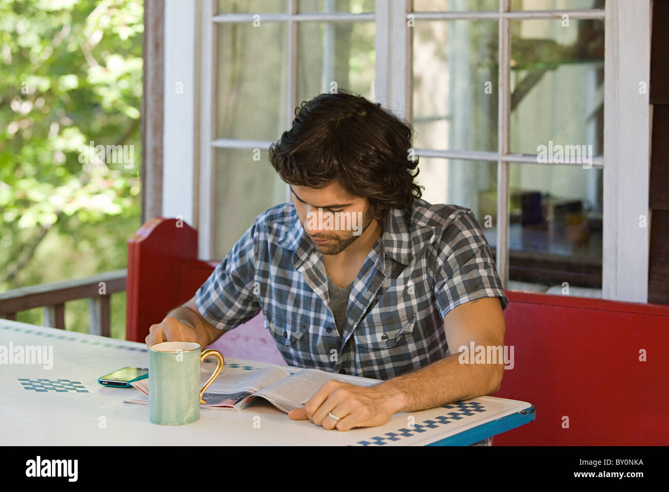 Young man reading magazine Stock Photo - Alamy