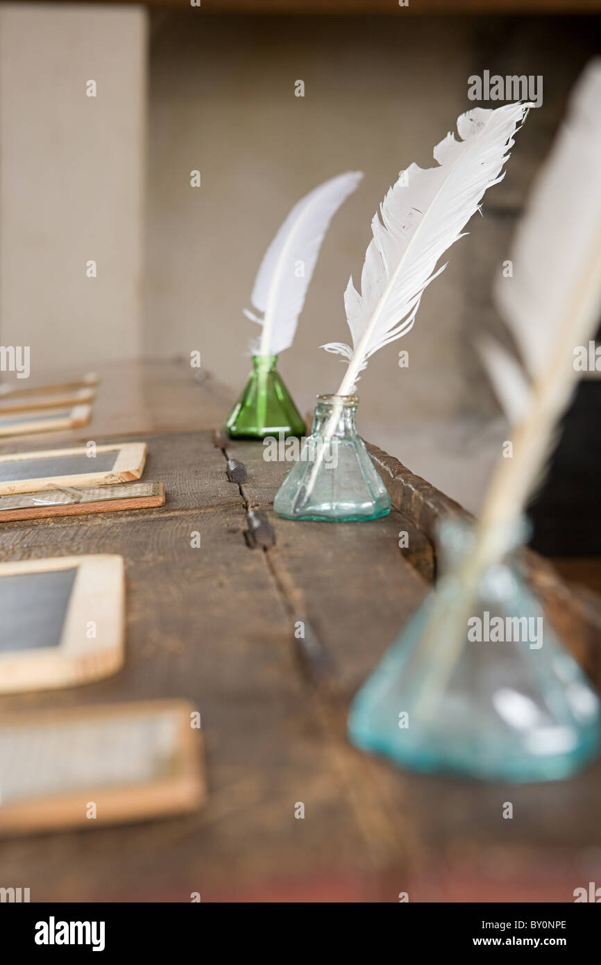 Quill pens and inkwells on old fashioned desks Stock Photo - Alamy