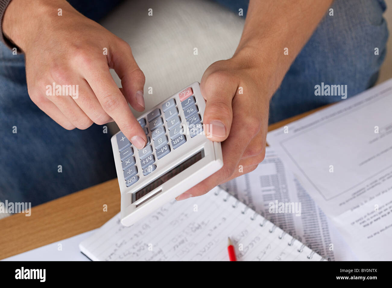 Young man using calculator Stock Photo - Alamy