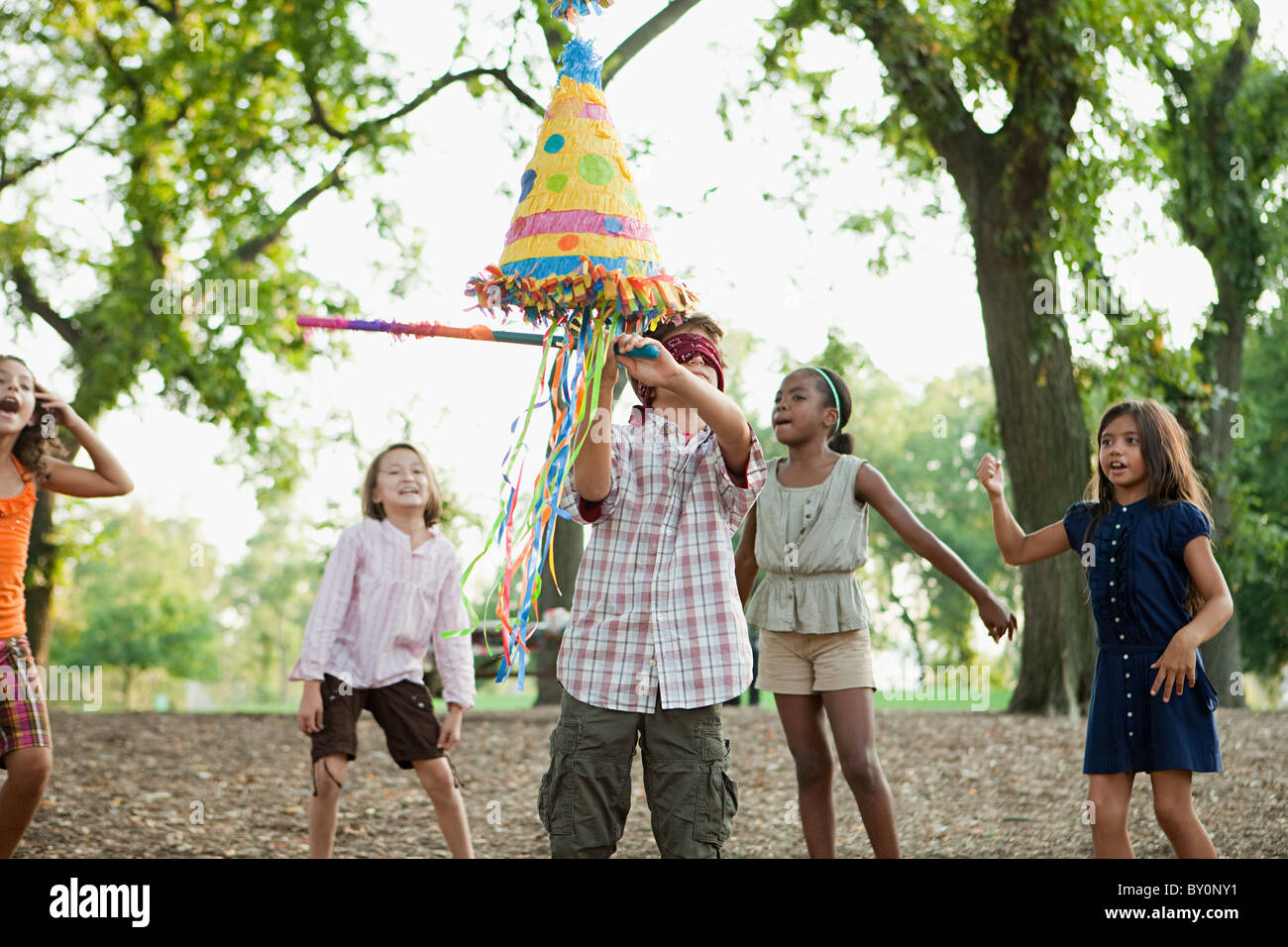 Boy at birthday party hitting pinata Stock Photo - Alamy