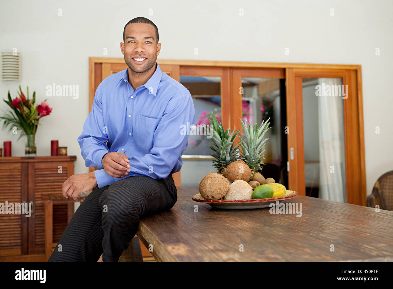 Young man sitting on table Stock Photo - Alamy