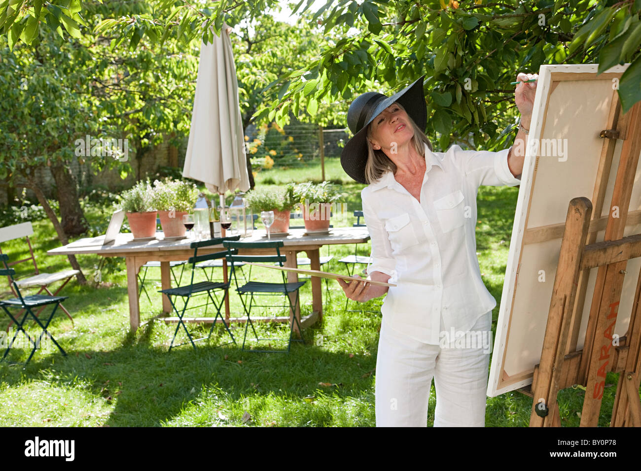 Mature woman painting at easel Stock Photo - Alamy