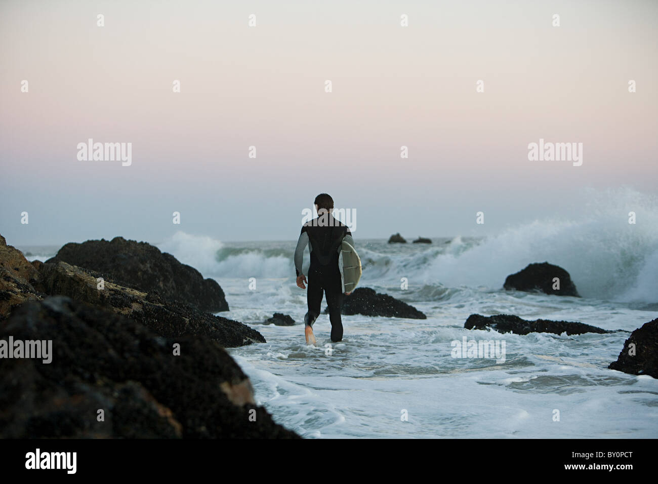 Surfer standing in the sea Stock Photo - Alamy