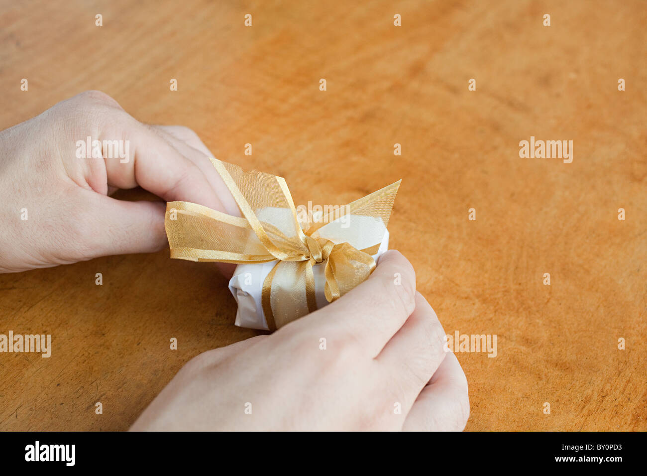 Person wrapping small gift Stock Photo - Alamy