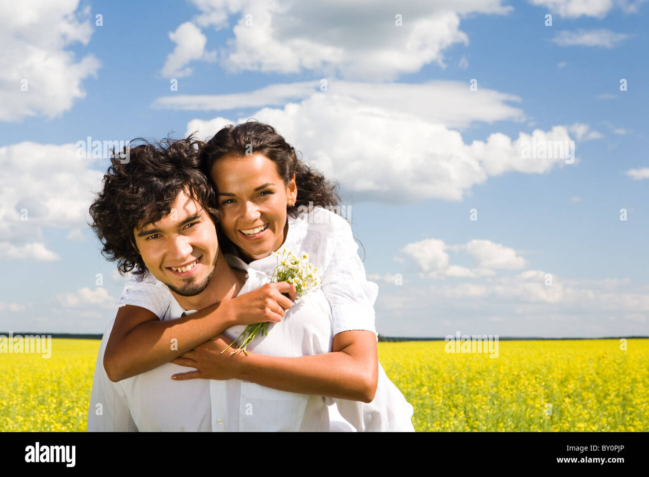 Portrait of smiling girl on man’s back hugging him tenderly Stock Photo ...