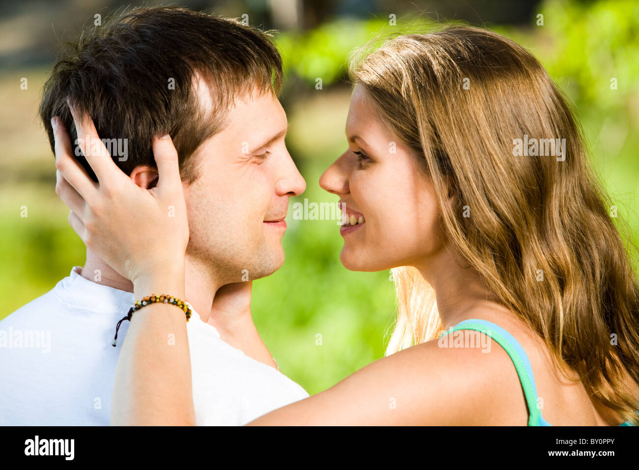 Profiles of amorous man and woman with their faces close to each other ...