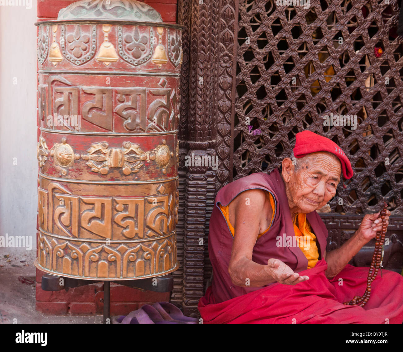 nun begging for alms at the Buddhist stupa of Boudhanath in Kathmandu ...