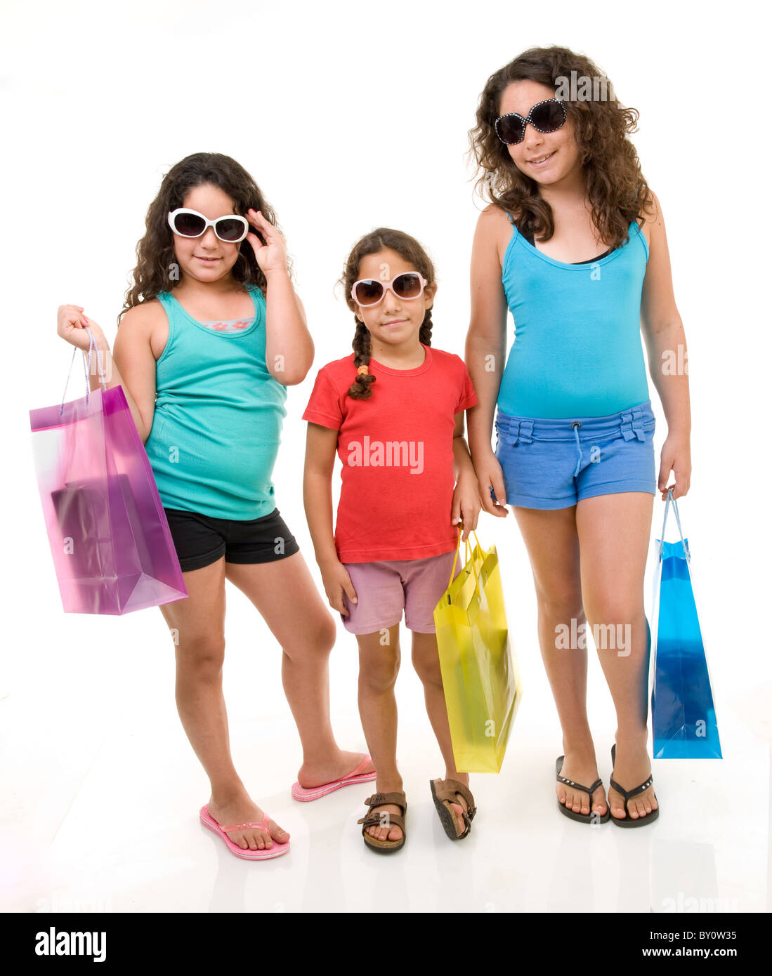 three young girls with shopping bags isolated on white Stock Photo - Alamy