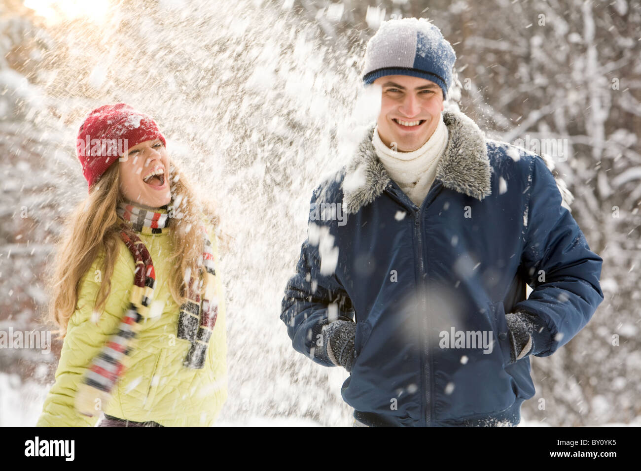 Portrait of joyful woman throwing snow at man Stock Photo - Alamy