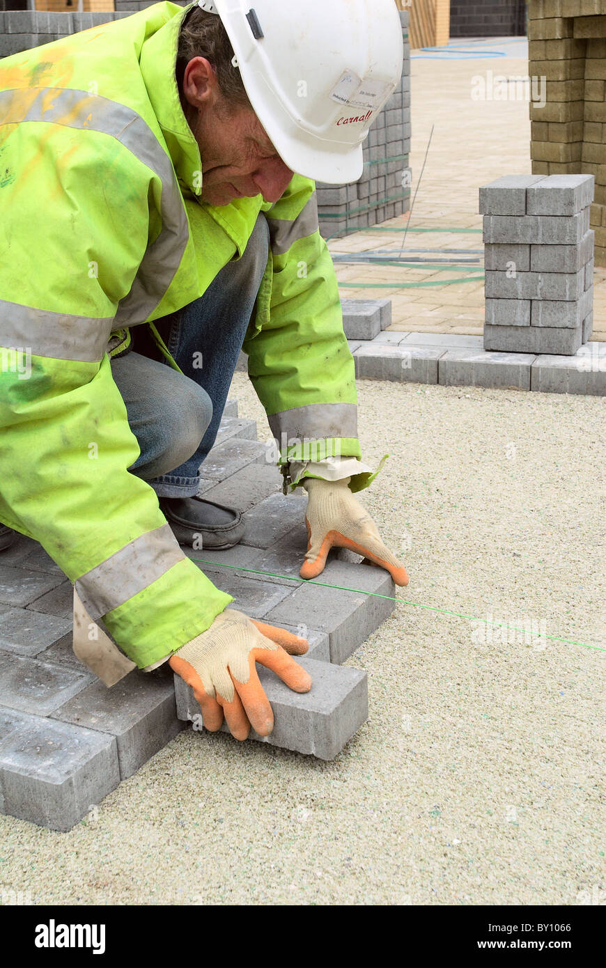 Laying paving stone on base made of recycled glass material. England UK ...