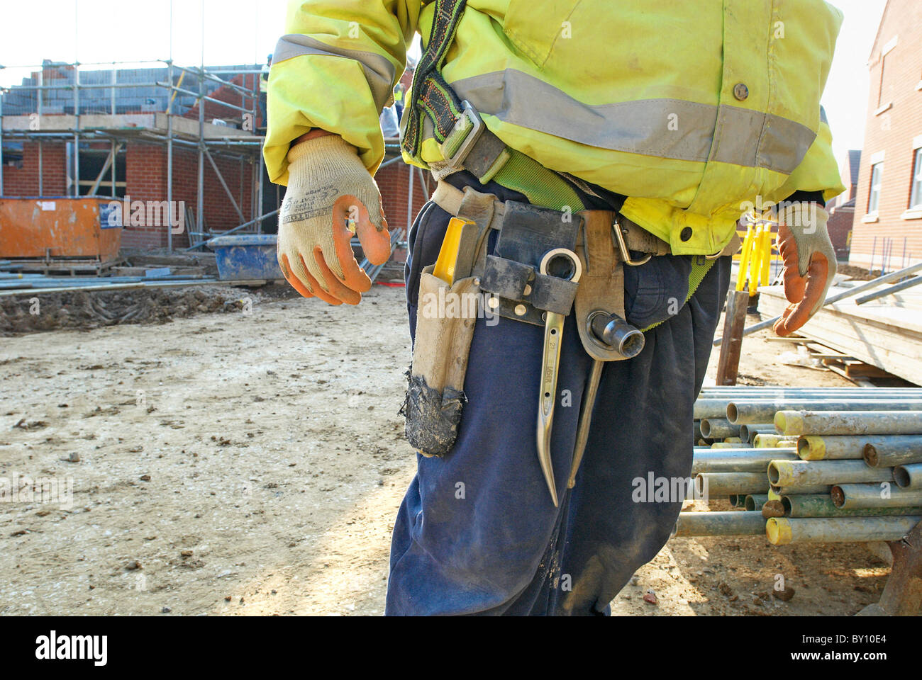 Worker with Toolbelt on a housing development site under construction ...