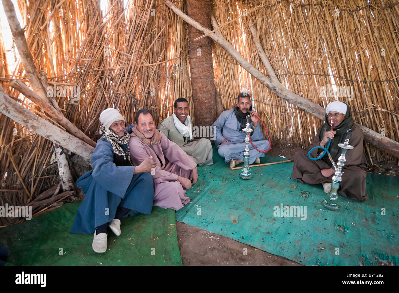 Men smoking shisha and tea drinking in rest area at Luxor Camel Market ...