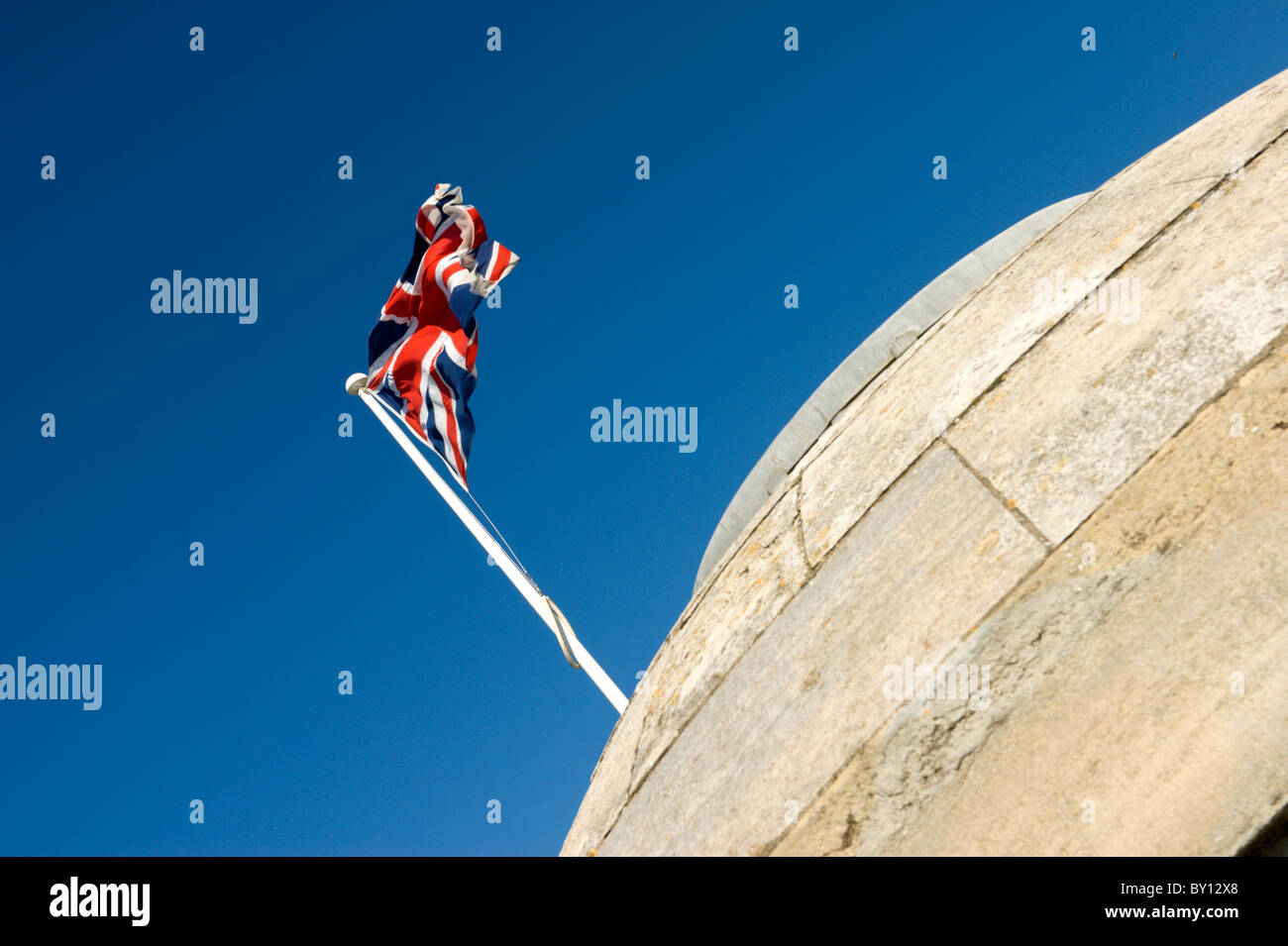 The Union Flag or union jack fluttering in a strong breeze above a ...