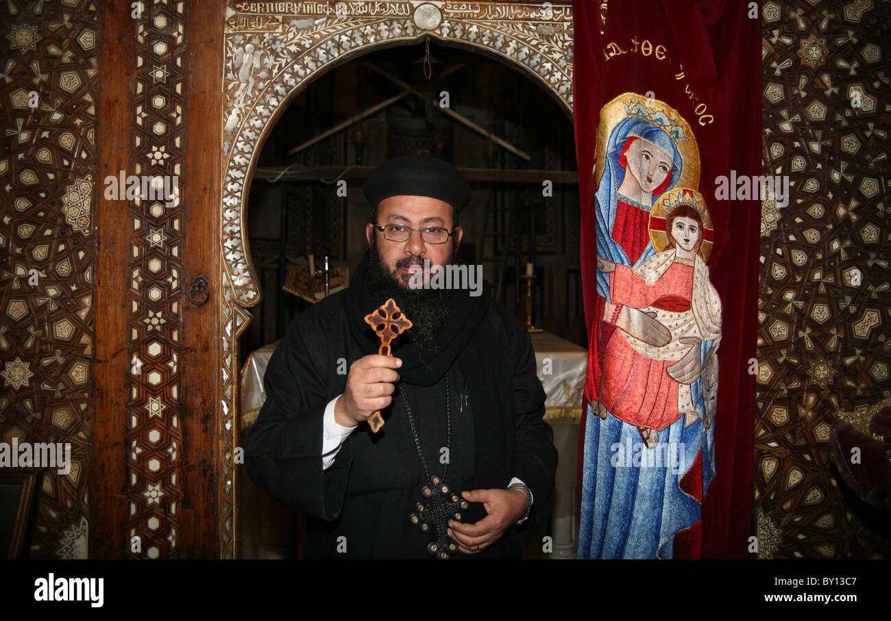 A Coptic priest in front of the iconastasis in the Church of the Holy ...