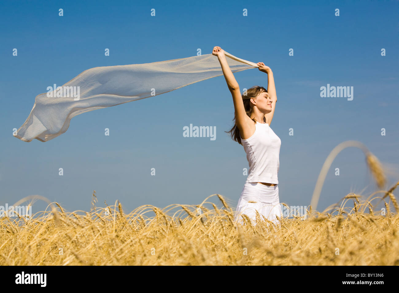 Portrait of charming young girl raising her hands with fabric Stock ...