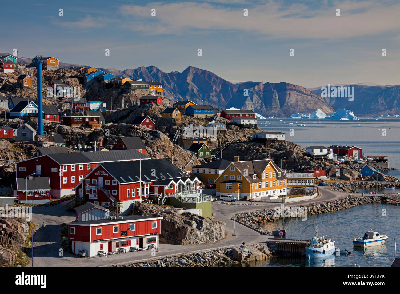 Uummannaq village with colourful houses and icebergs in the fjord ...