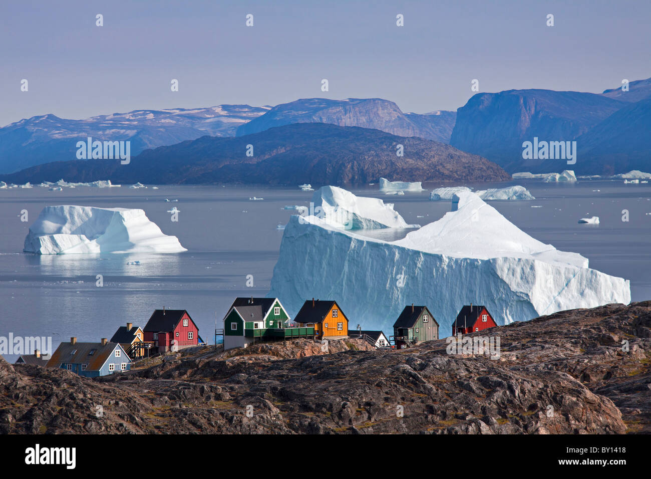 Uummannaq village with colourful houses and icebergs in the fjord ...