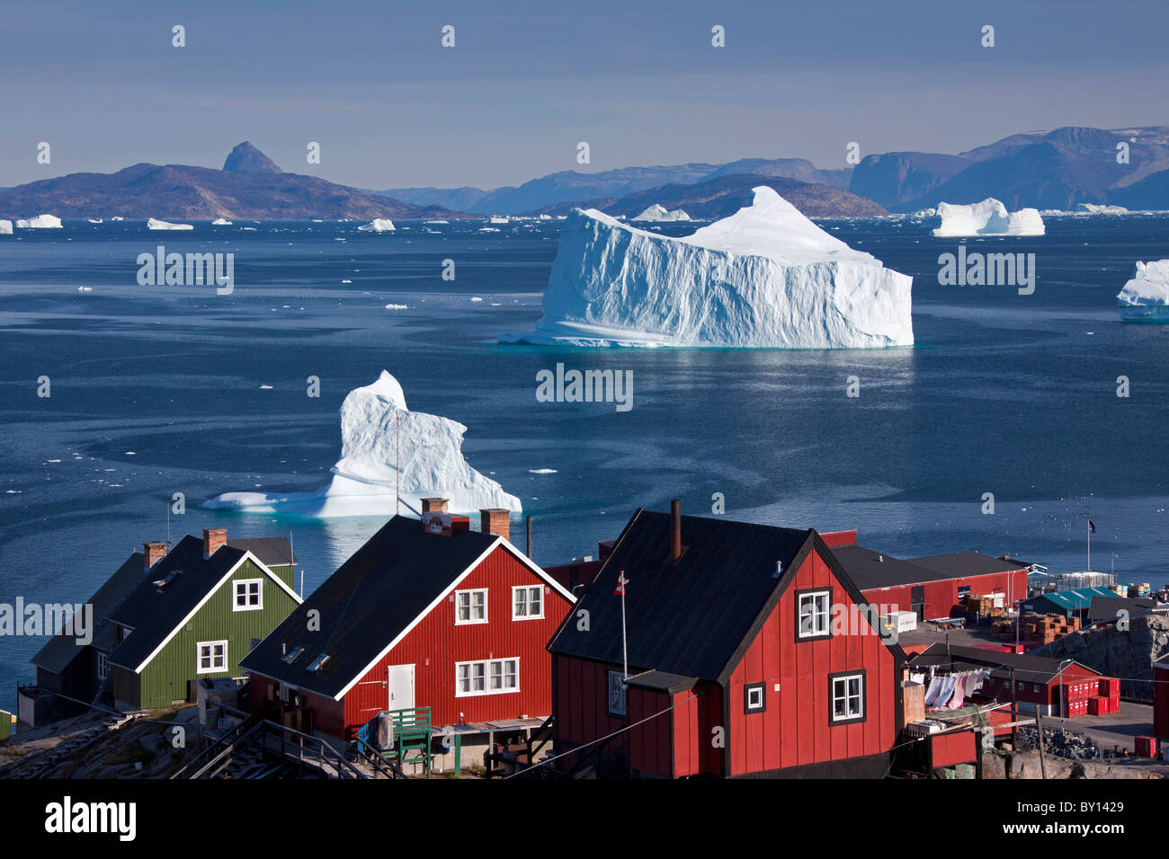 Uummannaq village with colourful houses and icebergs in the fjord ...