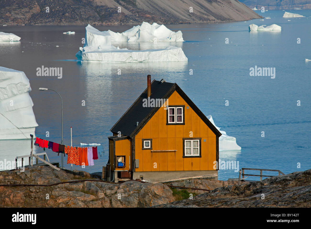 Uummannaq village with colourful houses and icebergs in the fjord ...