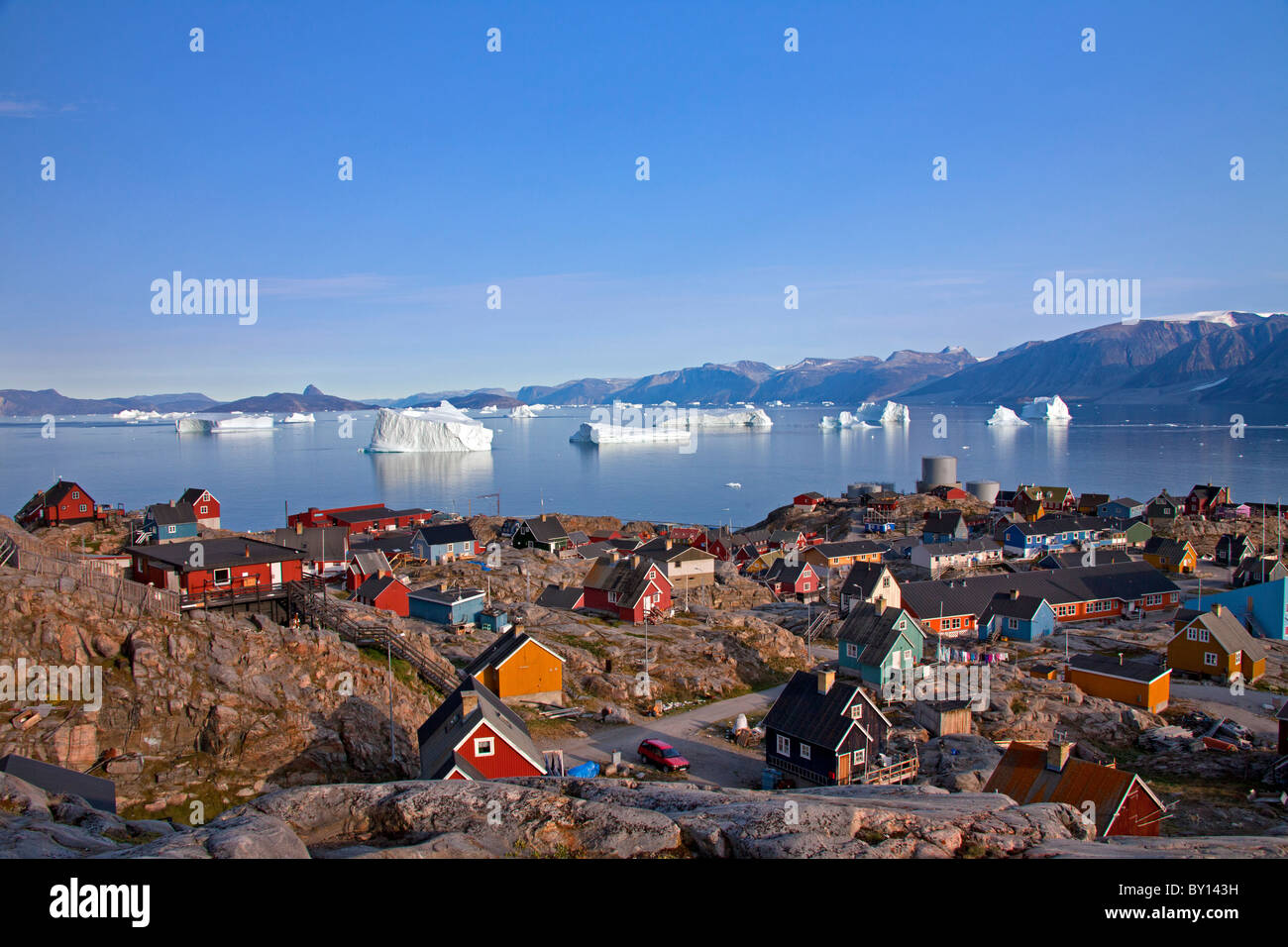 Uummannaq village with colourful houses and icebergs in the fjord ...