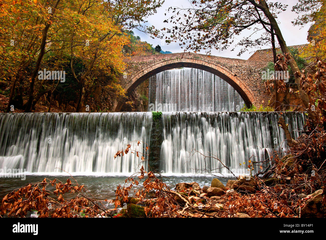 An old stone, arched bridge, between two waterfalls in Paleokarya ...