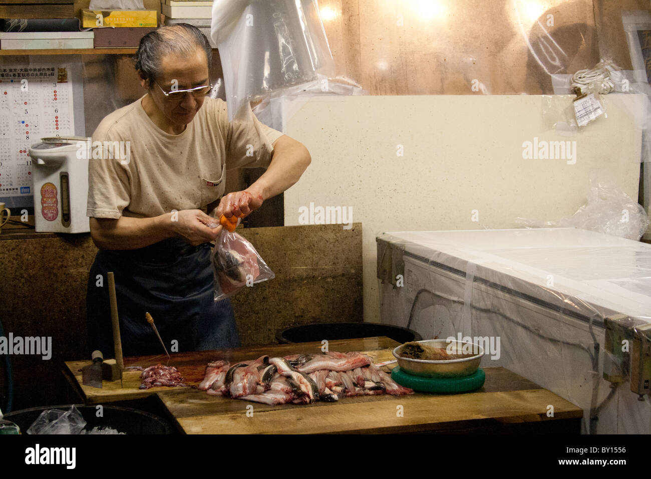 Fish monger bagging fish Stock Photo - Alamy