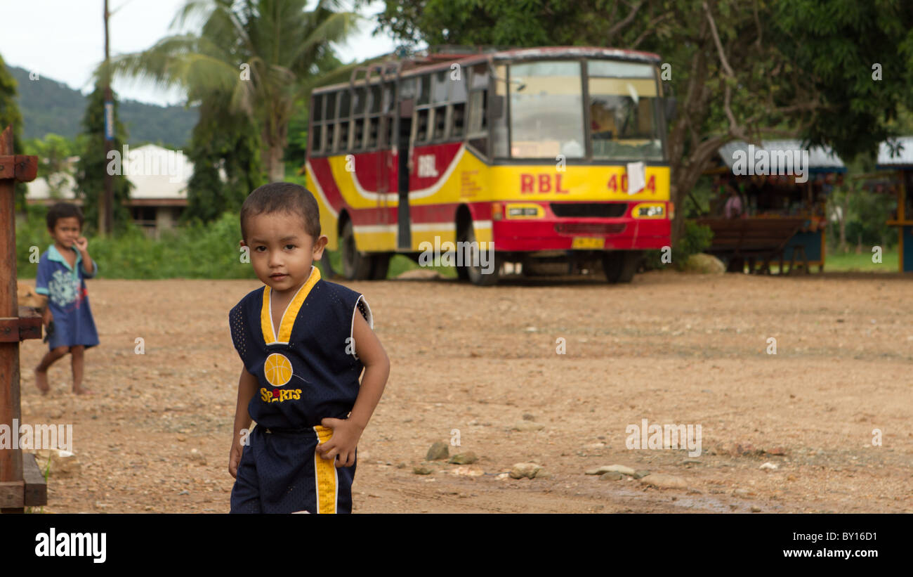A young boy in the gravel parking lot of a rural bus terminal Stock ...